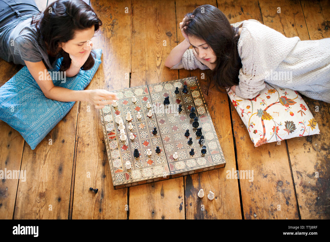 High angle view of sisters playing chess at home Stock Photo - Alamy