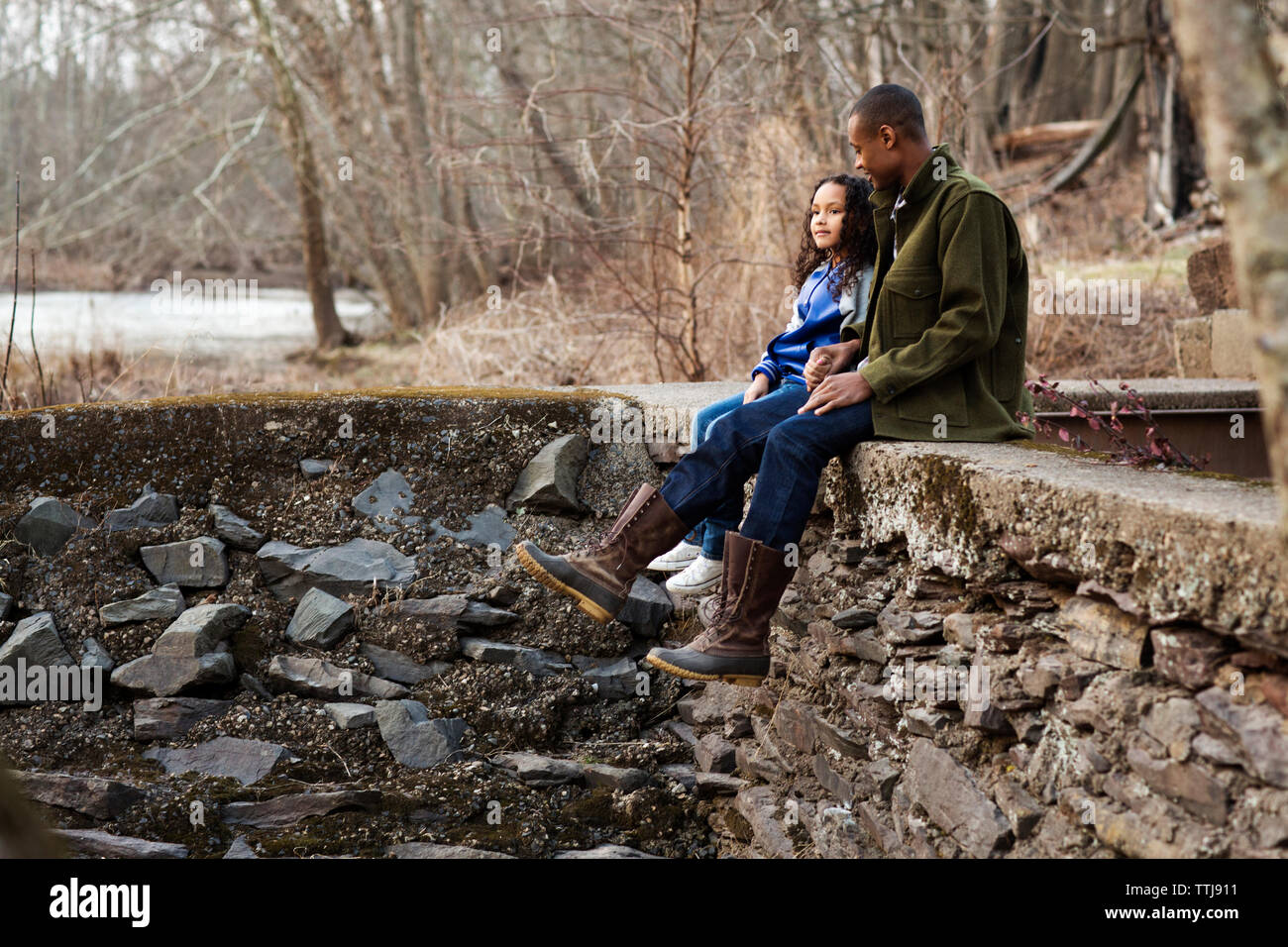Happy family sitting on retaining wall Stock Photo - Alamy