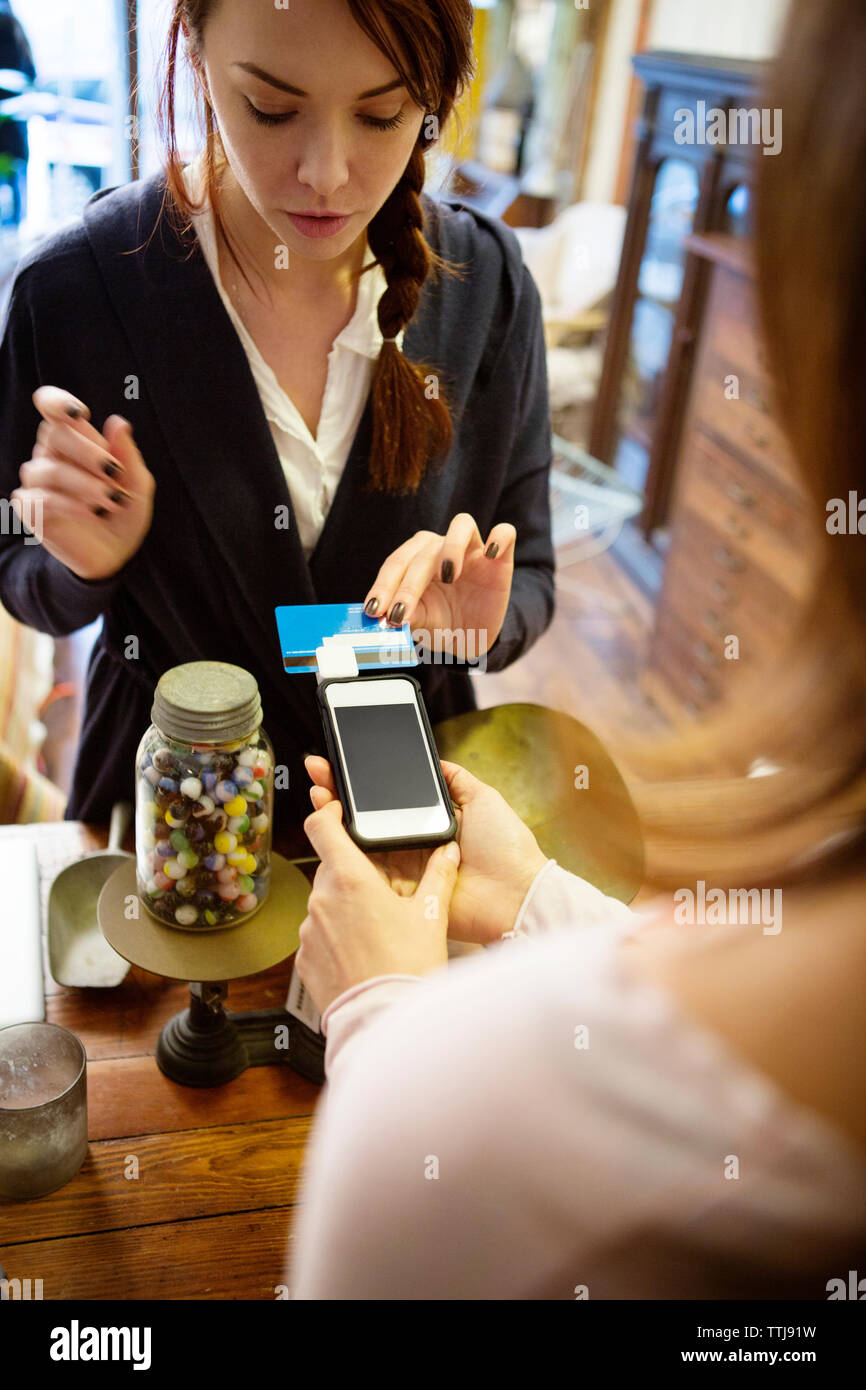 Customer paying through credit card at checkout counter in store Stock ...
