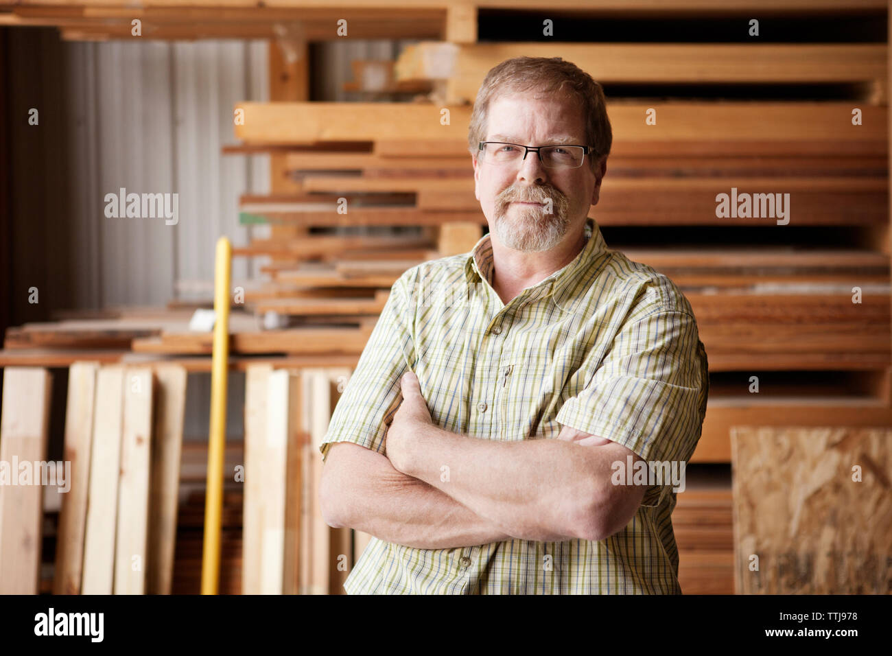 Portrait of carpenter with arms crossed standing in workshop Stock ...