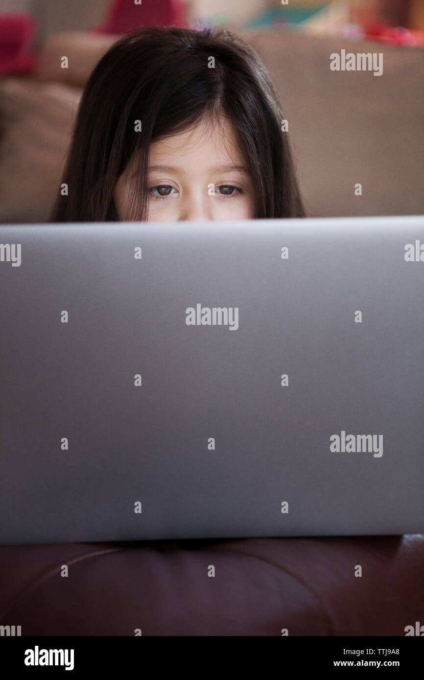 Cute girl looking at laptop computer in home Stock Photo - Alamy