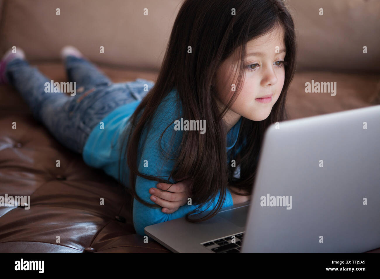 Girl using laptop computer while lying at home Stock Photo - Alamy