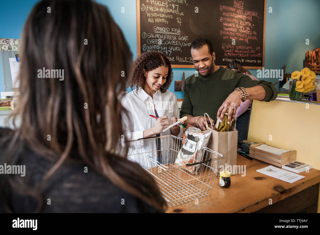 Owners preparing bill for customer in store Stock Photo - Alamy