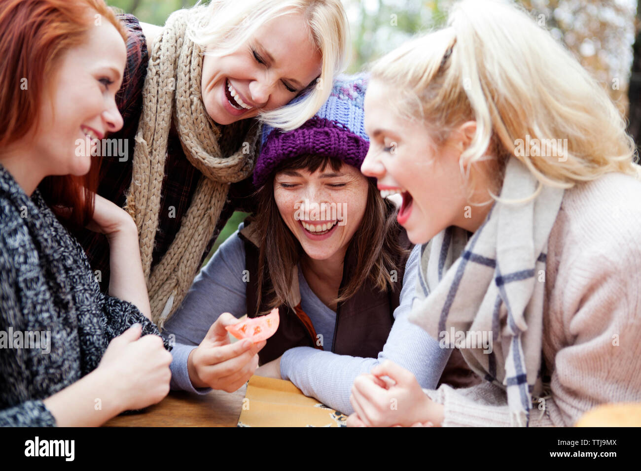 Happy friends laughing at table Stock Photo - Alamy