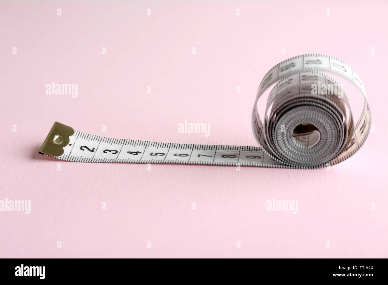 Measuring tape on pink background Stock Photo - Alamy