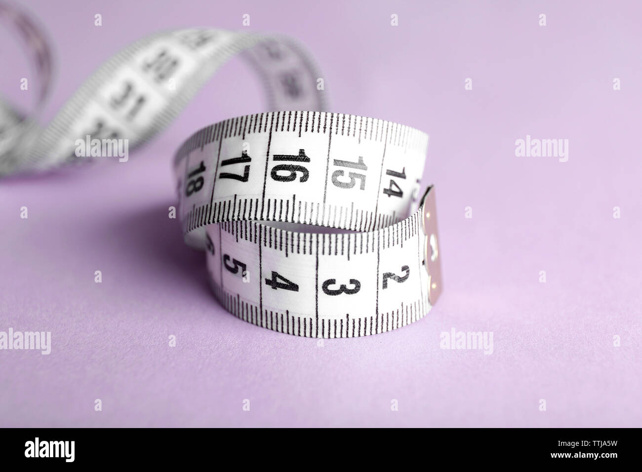 Measuring tape on purple background Stock Photo - Alamy