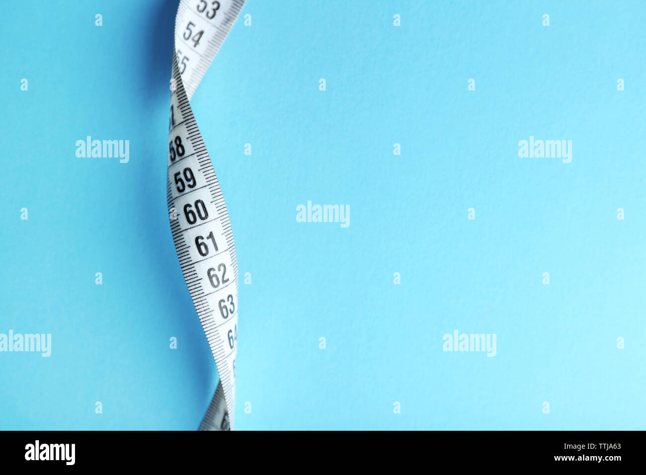 Measuring tape on blue background Stock Photo - Alamy