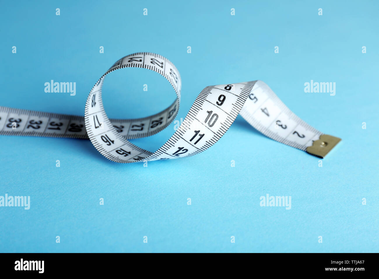 Measuring tape on blue background Stock Photo - Alamy