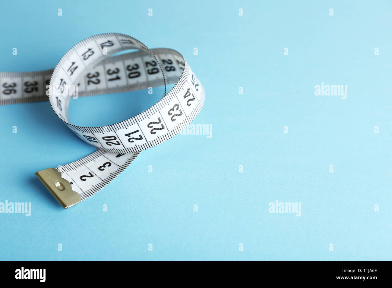 Measuring tape on blue background Stock Photo - Alamy