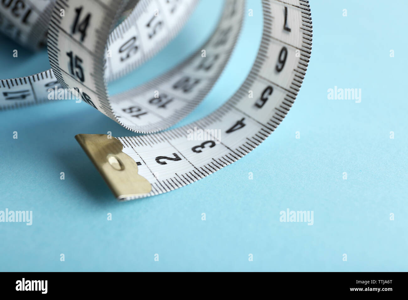 Measuring tape on blue background Stock Photo - Alamy