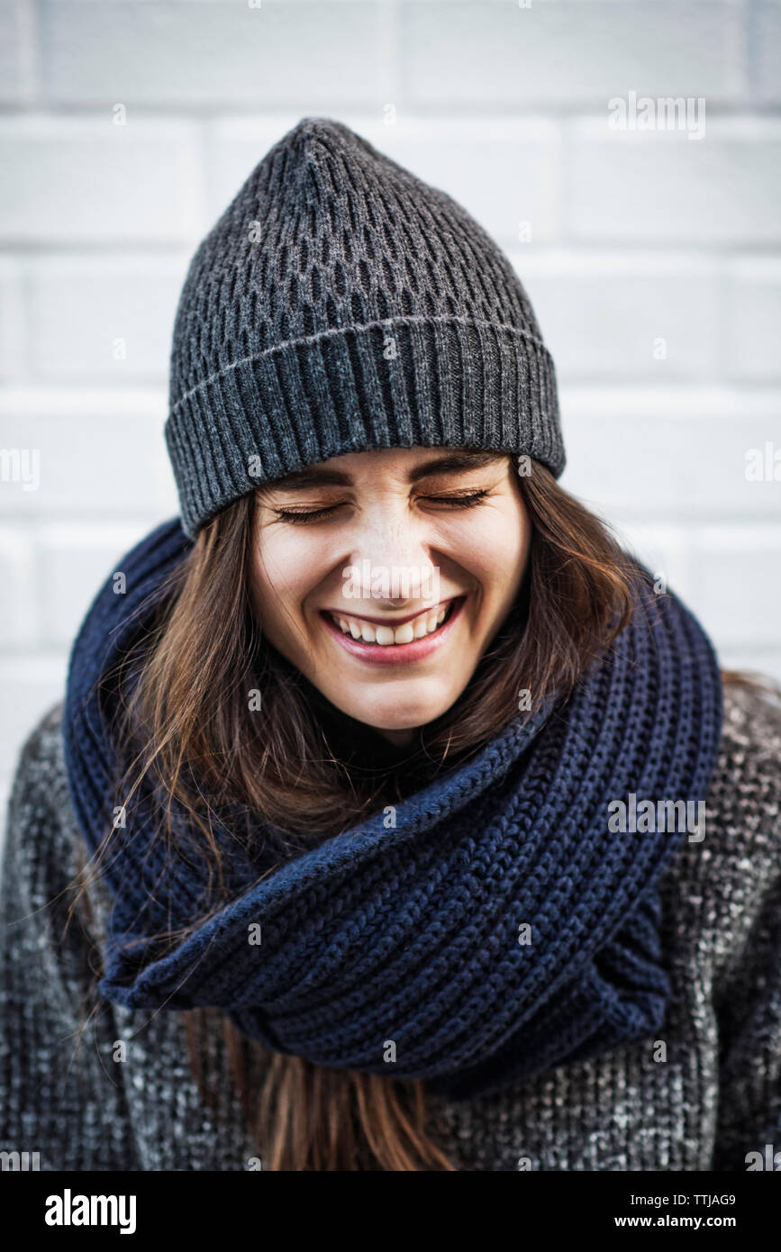 Cheerful woman laughing against brick wall Stock Photo - Alamy