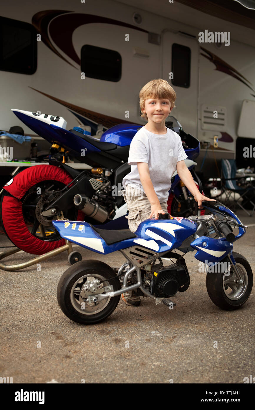 Portrait of boy standing by motorcycles Stock Photo - Alamy