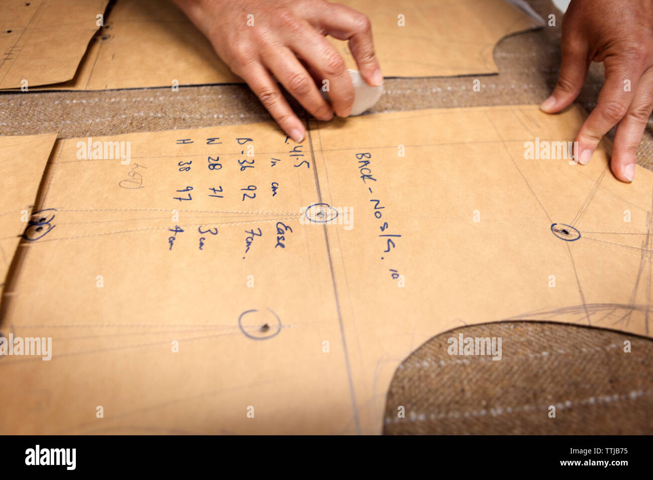 Cropped image of designer marking cloth with chalk Stock Photo - Alamy