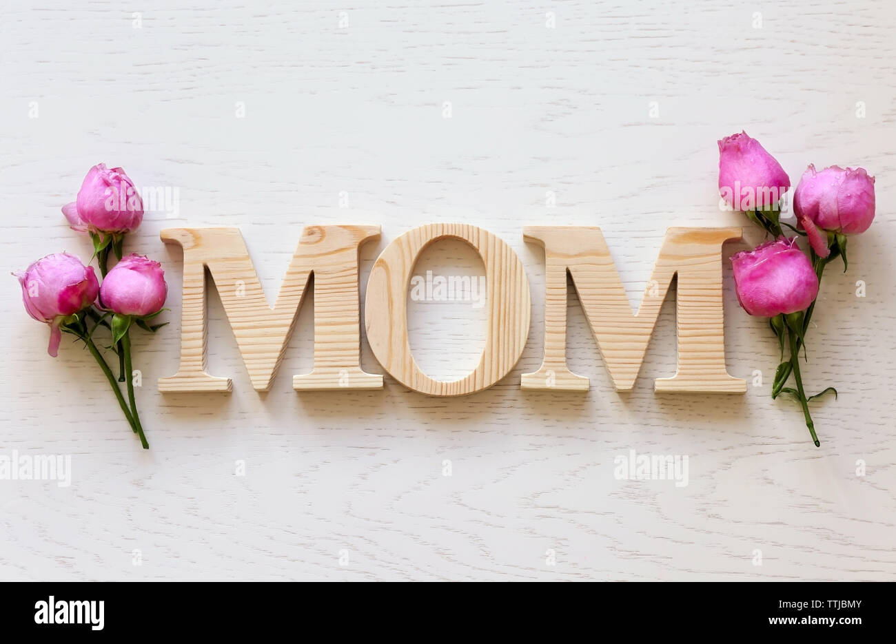 Mom word with fresh flowers on wooden background. Mother Day concept ...