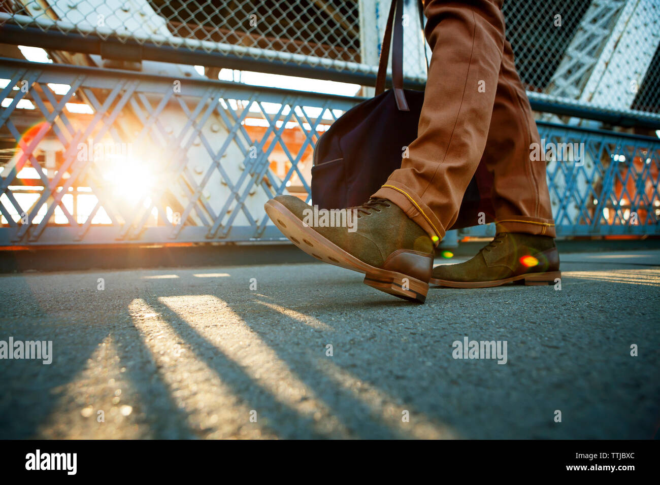 Low section of man walking on pedestrian walkway of Manhattan Bridge ...