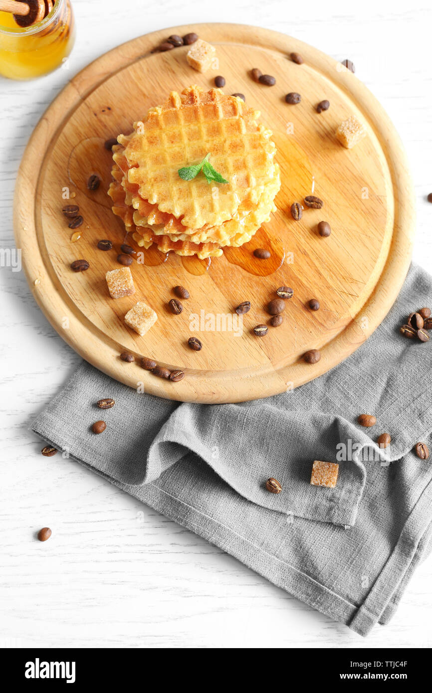 Tasty waffles with honey and mint on cutting board Stock Photo - Alamy