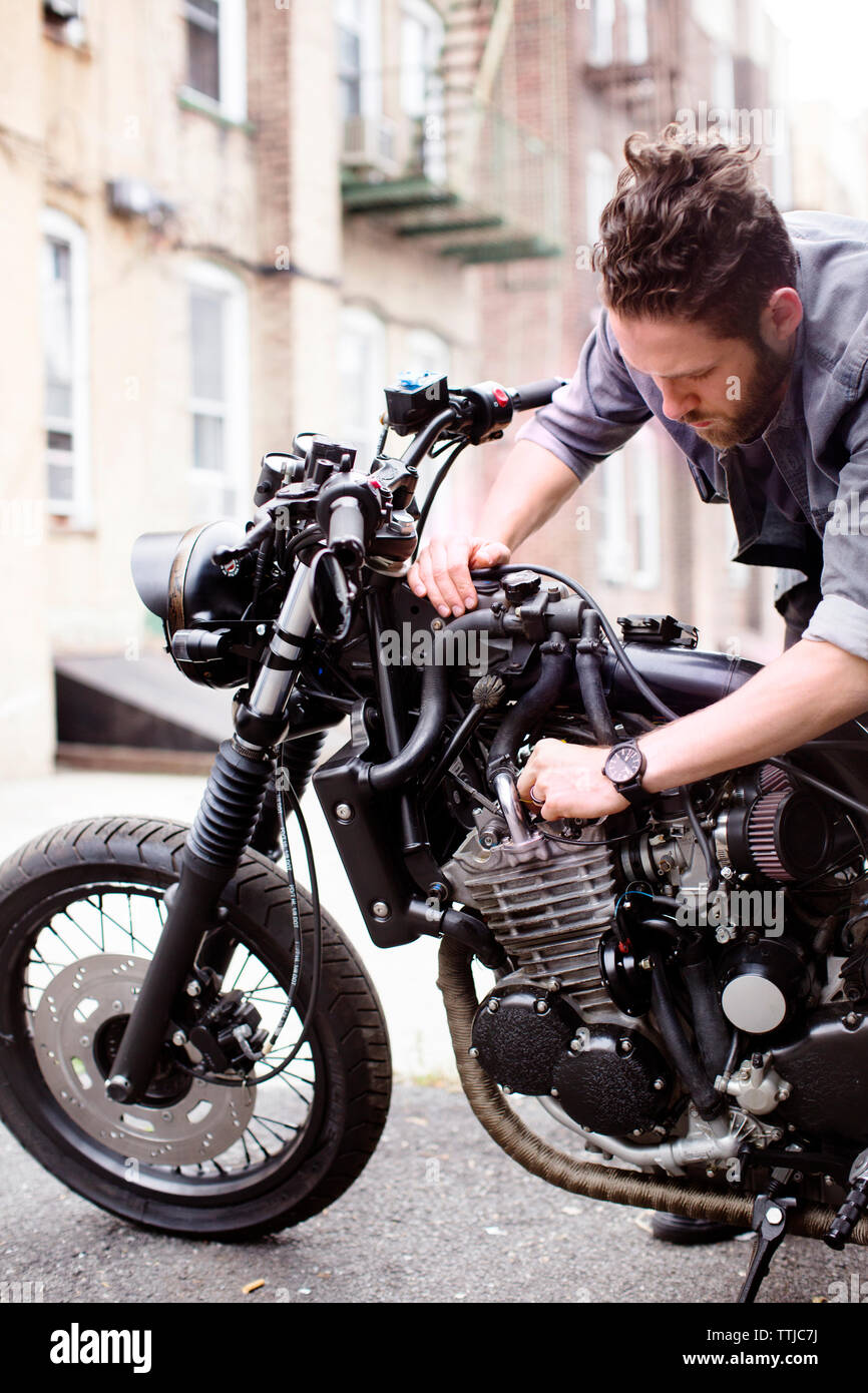 Man fixing motorcycle on street Stock Photo - Alamy