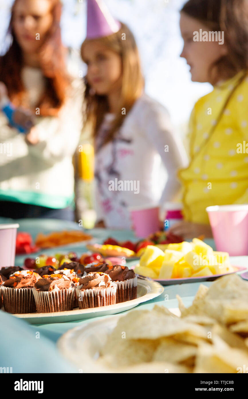 Food arrange at table while girls standing with woman in party Stock ...
