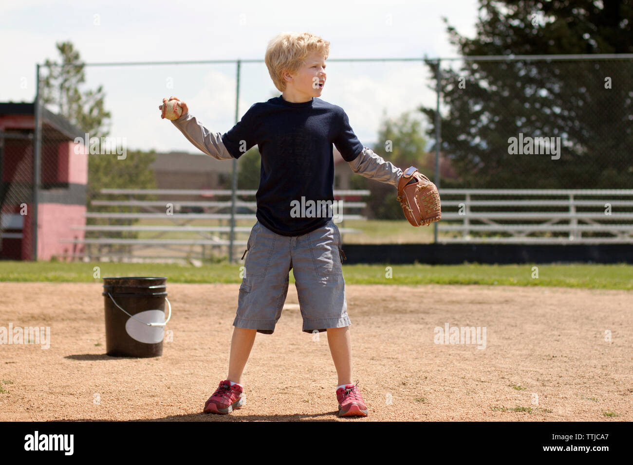 Boy playing baseball at field Stock Photo - Alamy