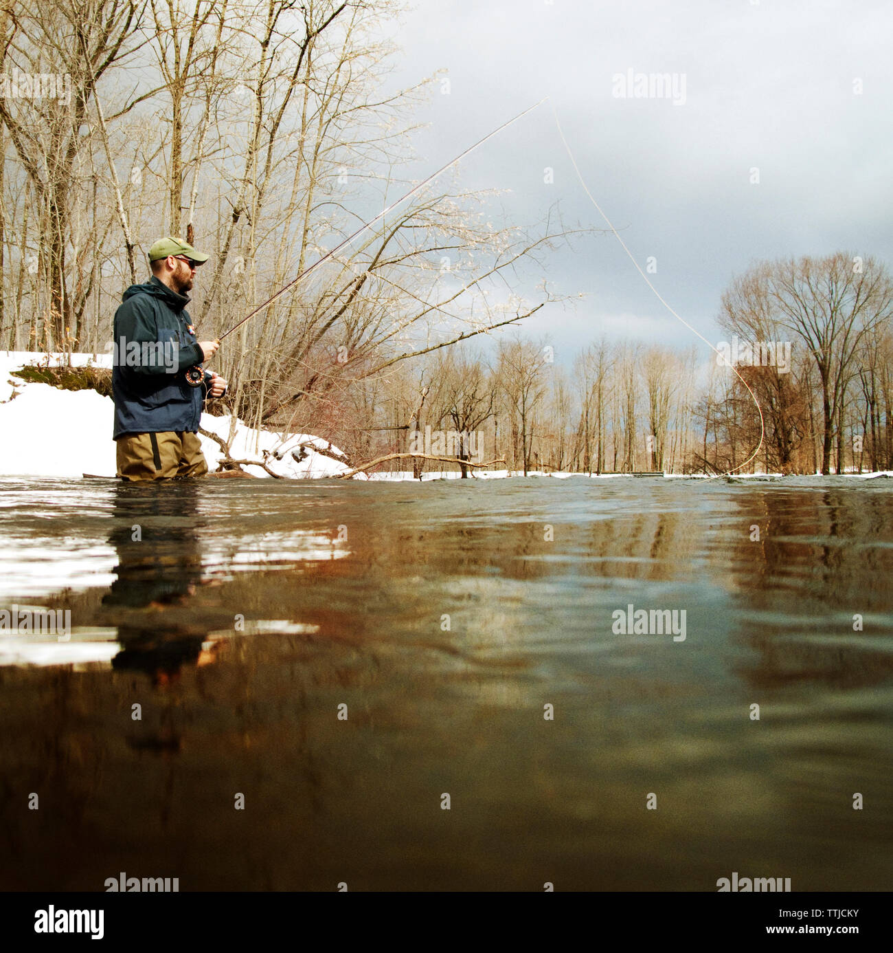 Side view of man fishing in lake Stock Photo - Alamy