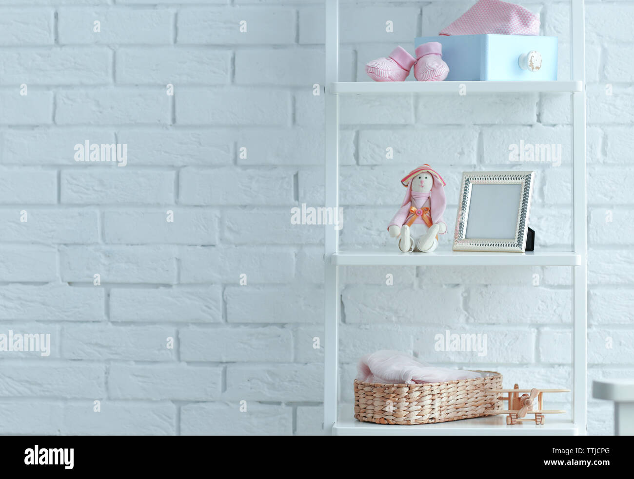 Baby toys and clothes on brick wall background Stock Photo - Alamy