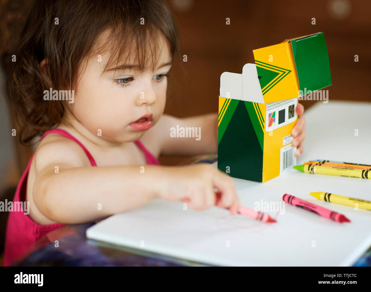 Girl playing with crayons Stock Photo - Alamy