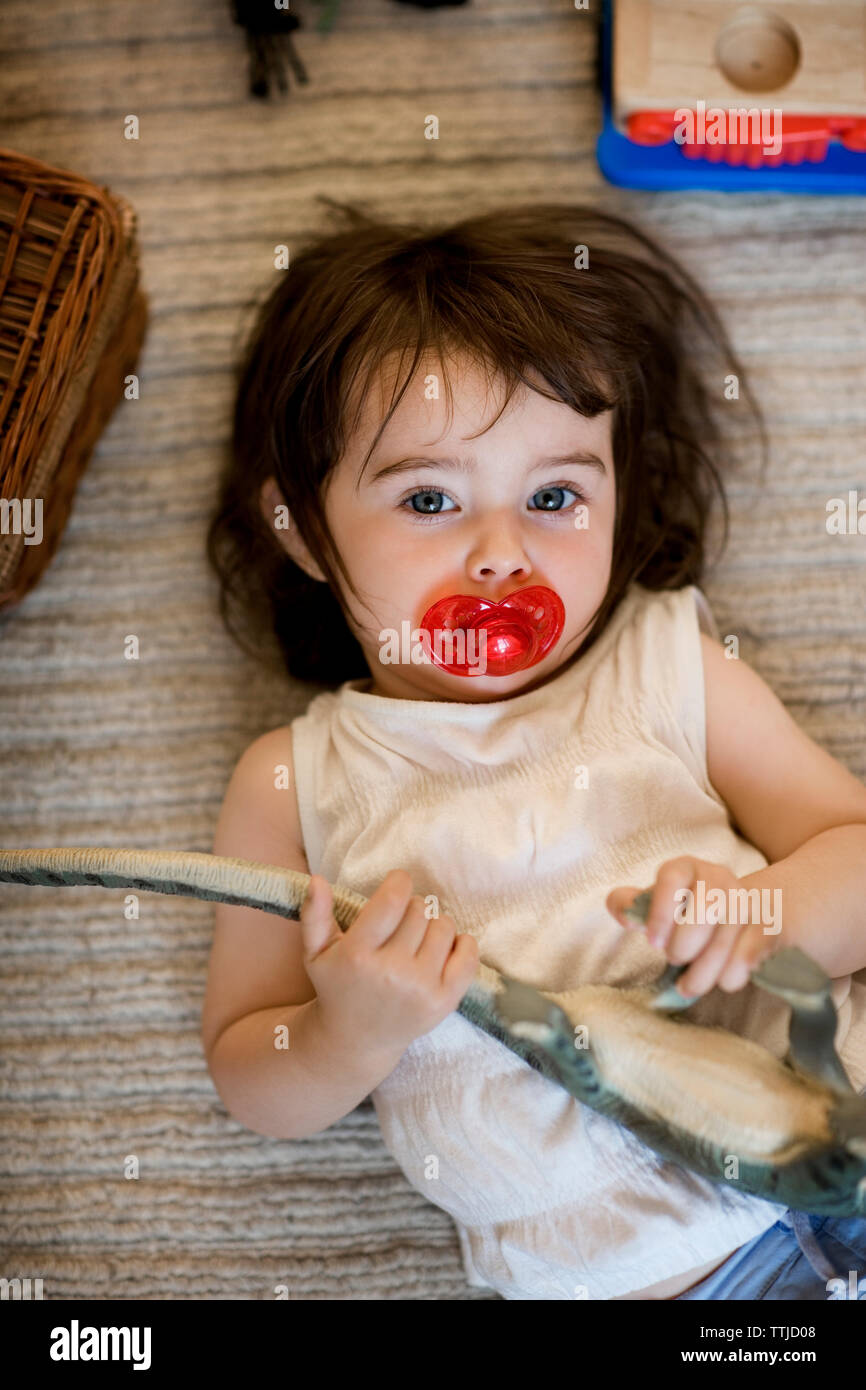Overhead view of girl with pacifier in mouth at home Stock Photo - Alamy