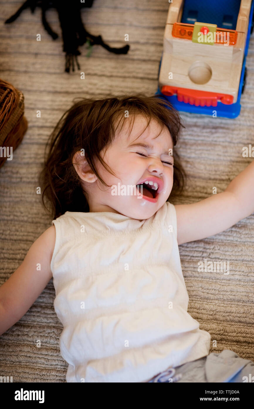 Overhead view of girl crying while lying on floor at home Stock Photo ...