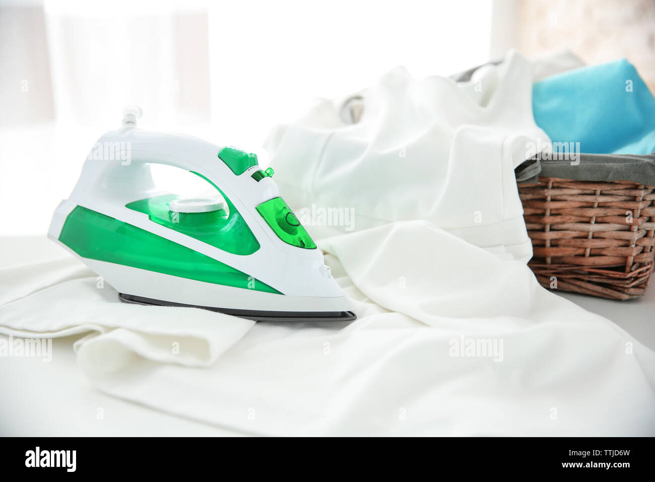 Iron and clothes indoors Stock Photo - Alamy