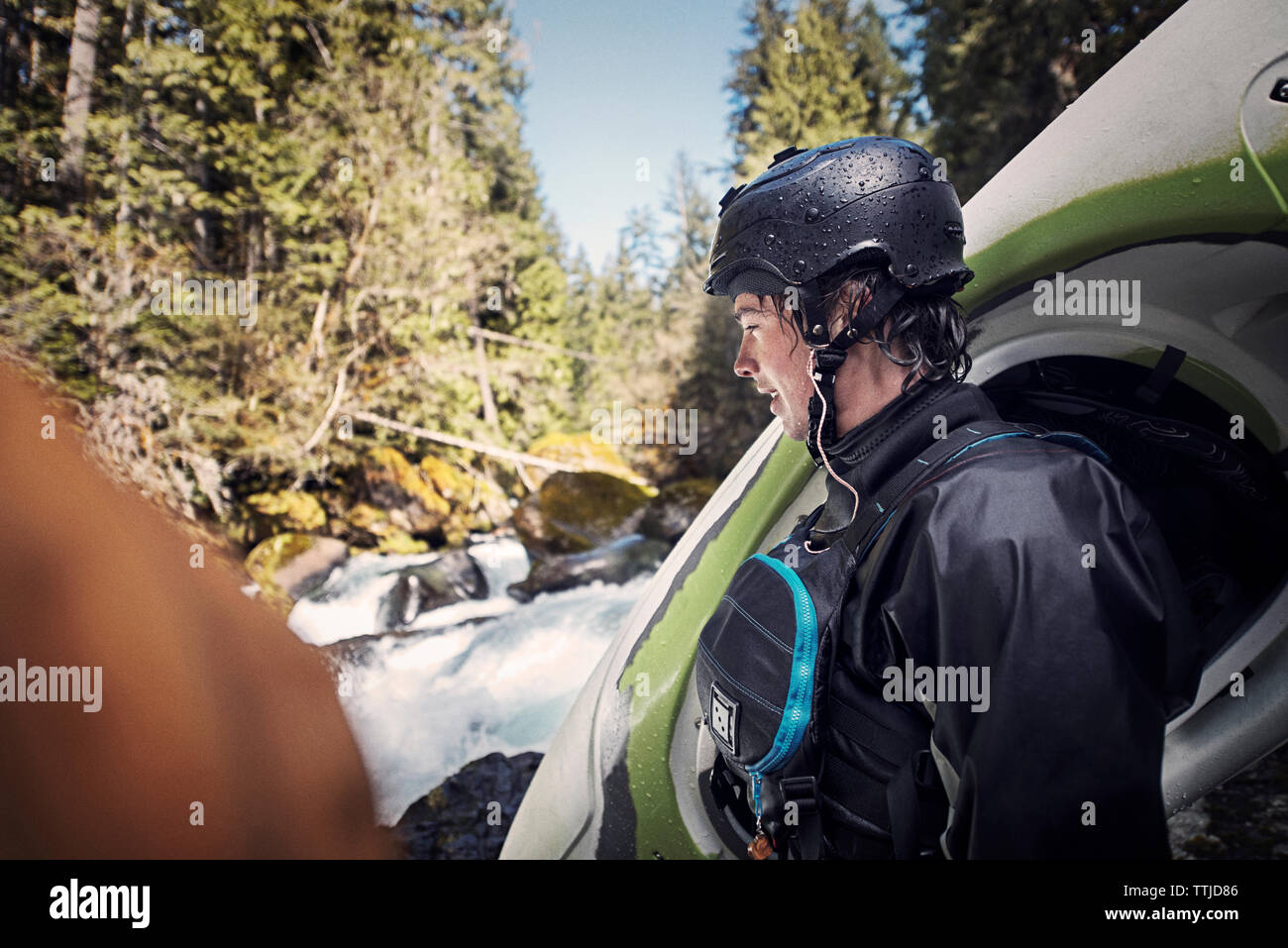 Man carrying kayak while standing by friend Stock Photo - Alamy