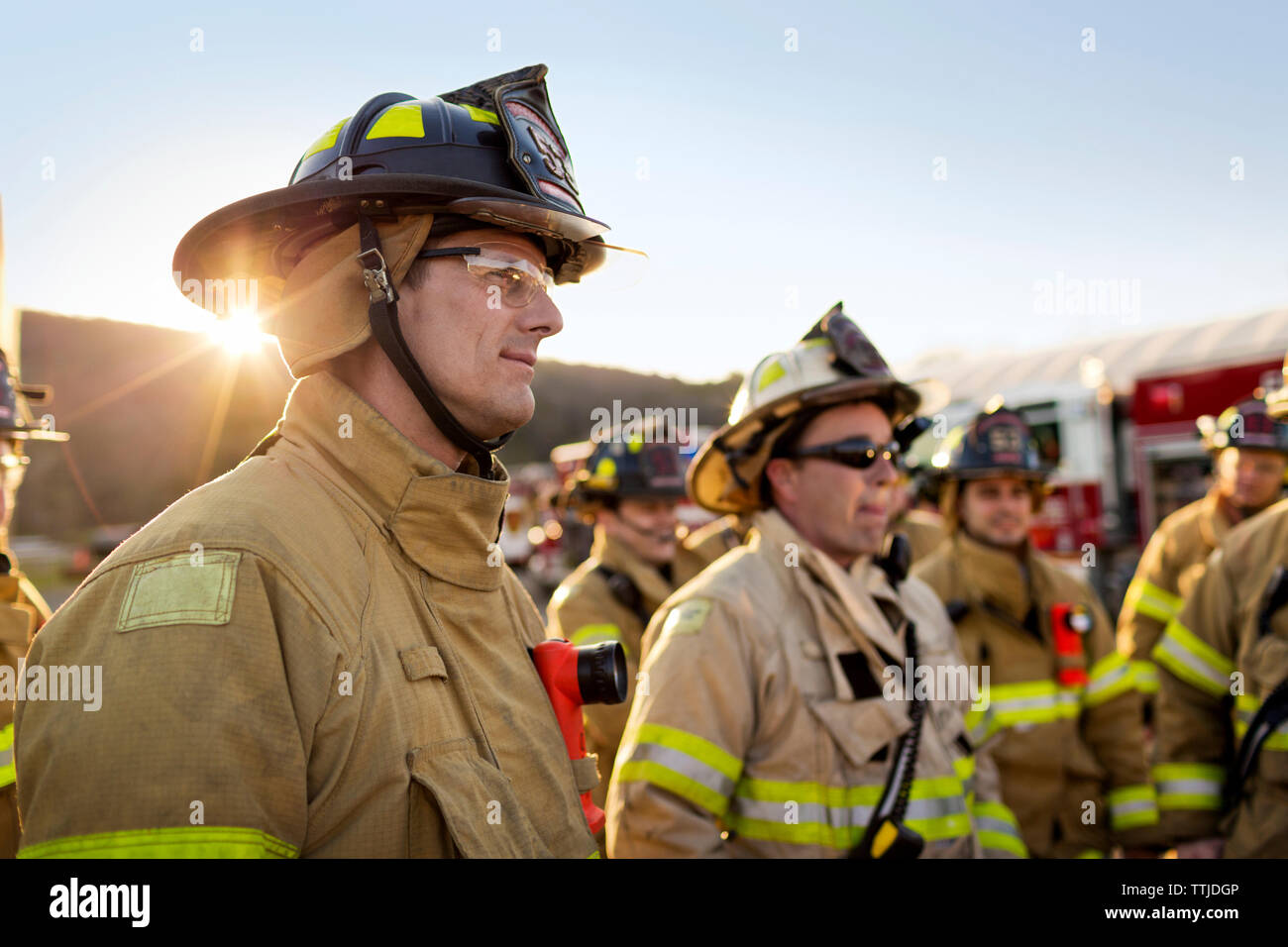 Firefighters standing at fire station Stock Photo - Alamy