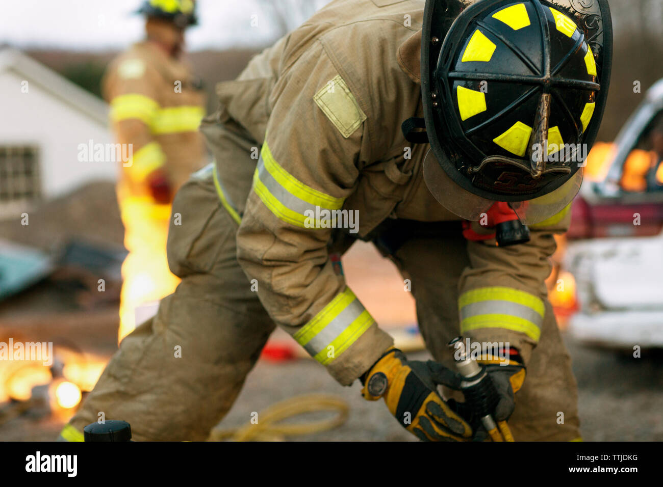 Firefighter bending at field Stock Photo - Alamy