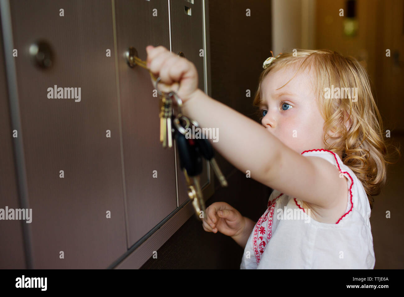 Baby girl opening locker at home Stock Photo - Alamy
