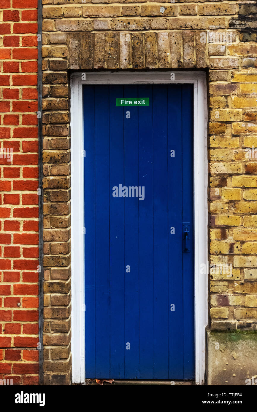 Blue painted wooden Door with Fire Exit plate in Brick Wall Stock Photo ...