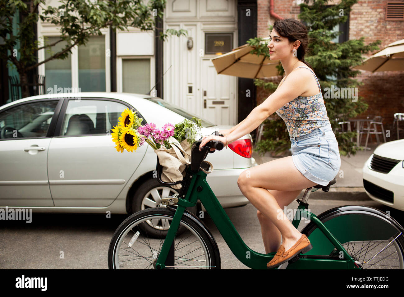 Woman riding bicycle on street in city Stock Photo - Alamy