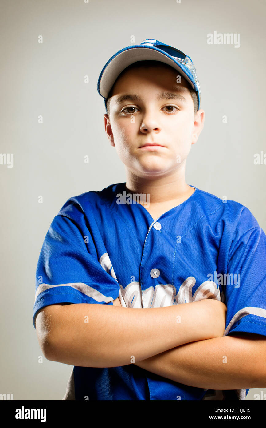 Portrait of baseball player with arms crossed against white background ...