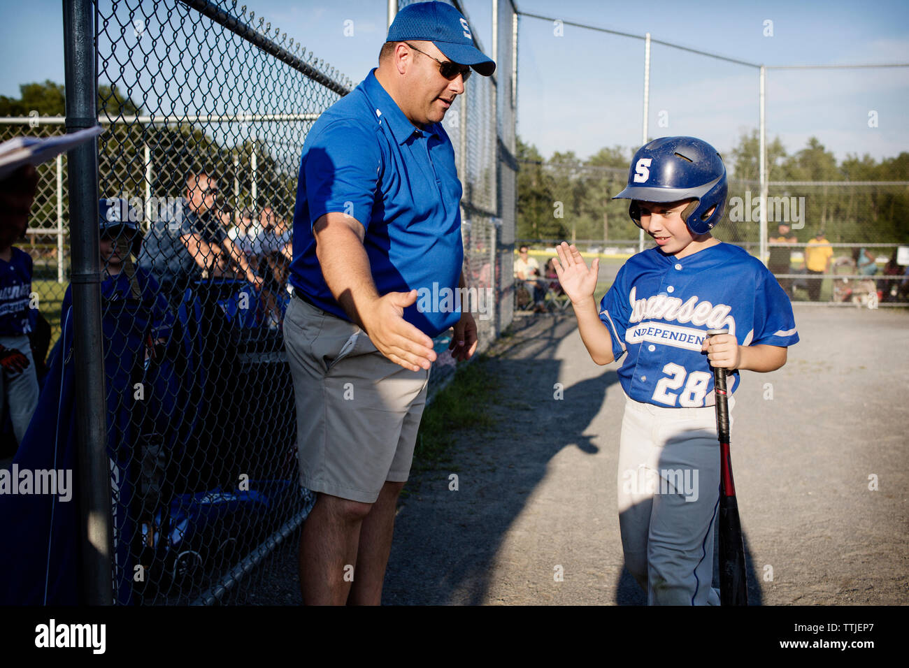 Coach high fiving player in field Stock Photo - Alamy