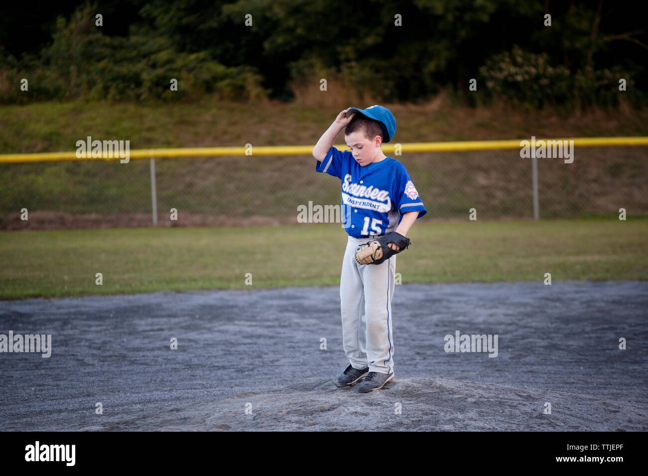Boy playing baseball on field Stock Photo - Alamy