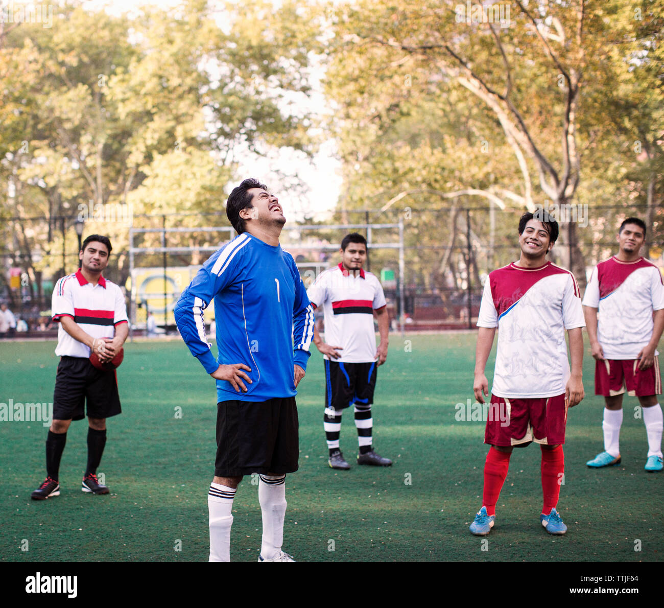 Soccer players laughing while standing on field Stock Photo - Alamy