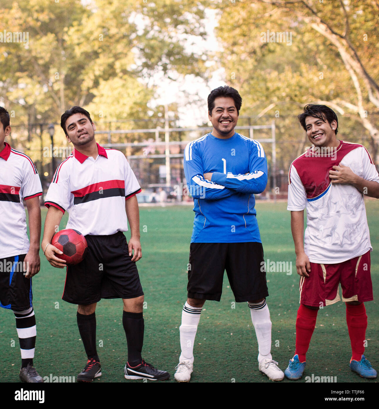 Happy soccer players standing at soccer field Stock Photo - Alamy