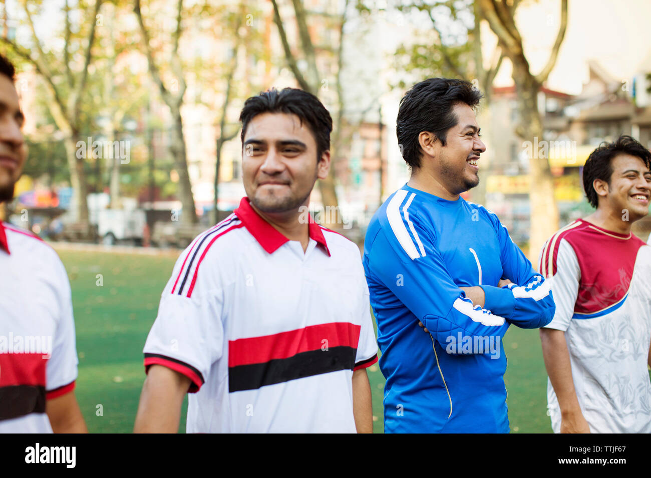 Happy athletes standing at soccer field Stock Photo - Alamy