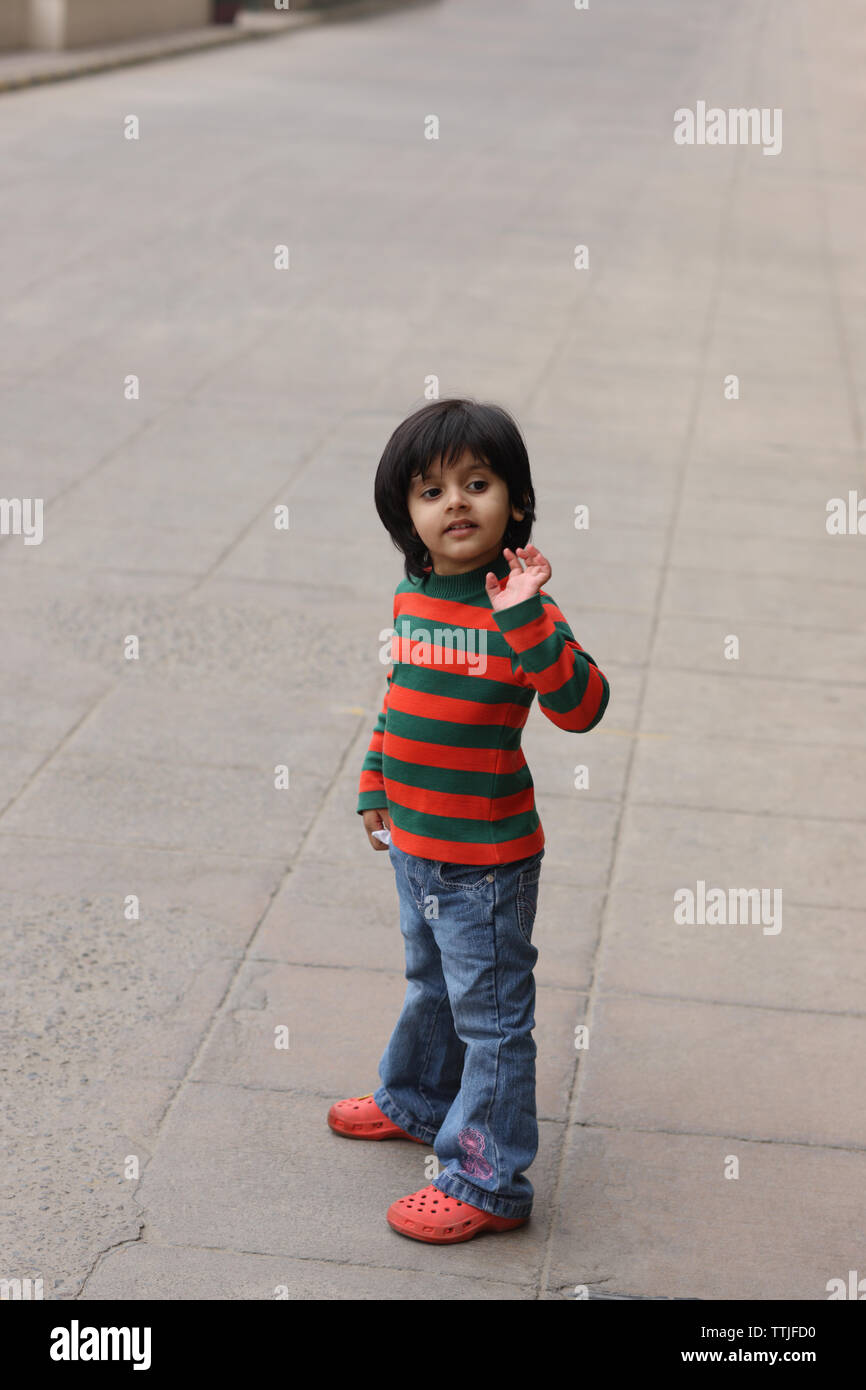 Girl standing with hand raised Stock Photo - Alamy