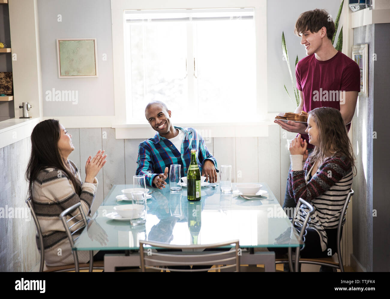 Happy friends by dining table at home Stock Photo - Alamy