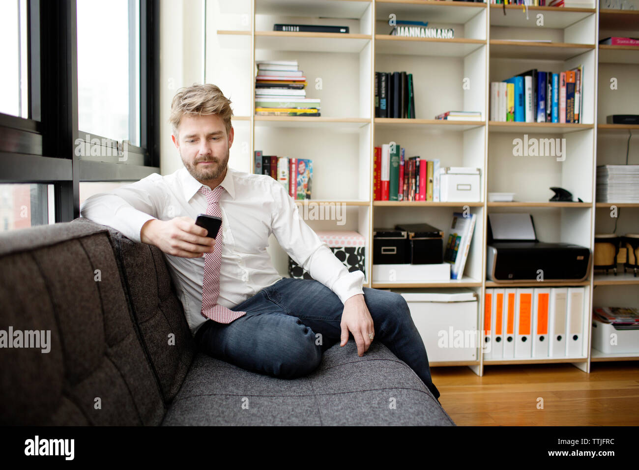 Man using mobile sitting on sofa hi-res stock photography and images ...