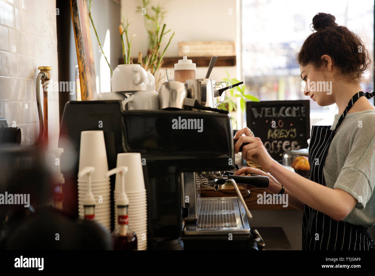 Young owner making coffee hi-res stock photography and images - Alamy
