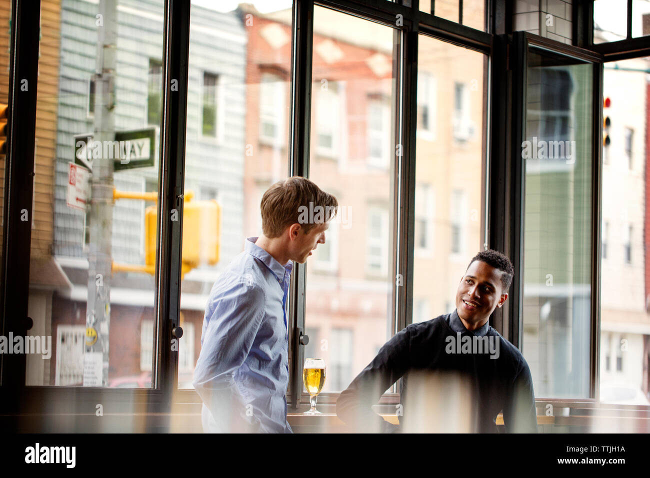 Male friends talking in bar Stock Photo - Alamy