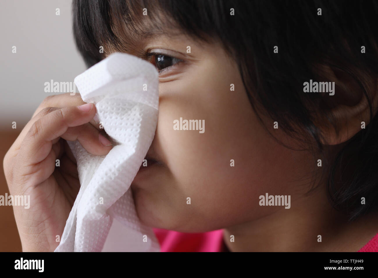 Girl blowing nose with tissue paper Stock Photo - Alamy
