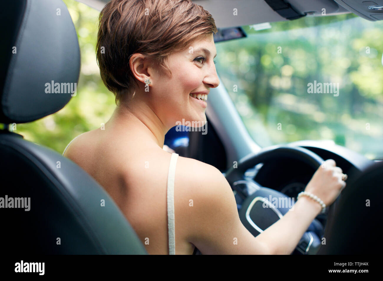 Woman looking away while driving car Stock Photo - Alamy