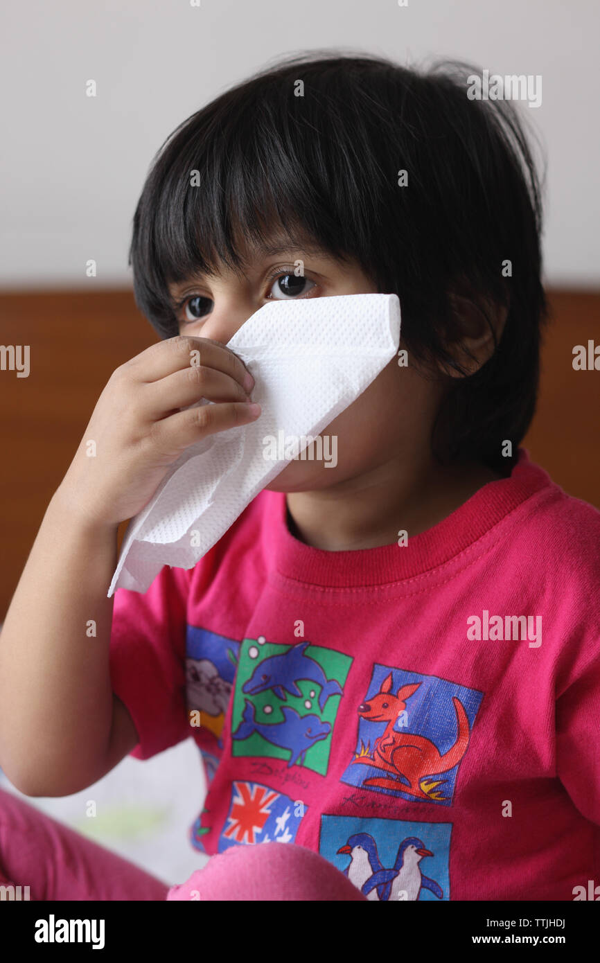 Indian girl blowing nose with tissue paper Stock Photo - Alamy
