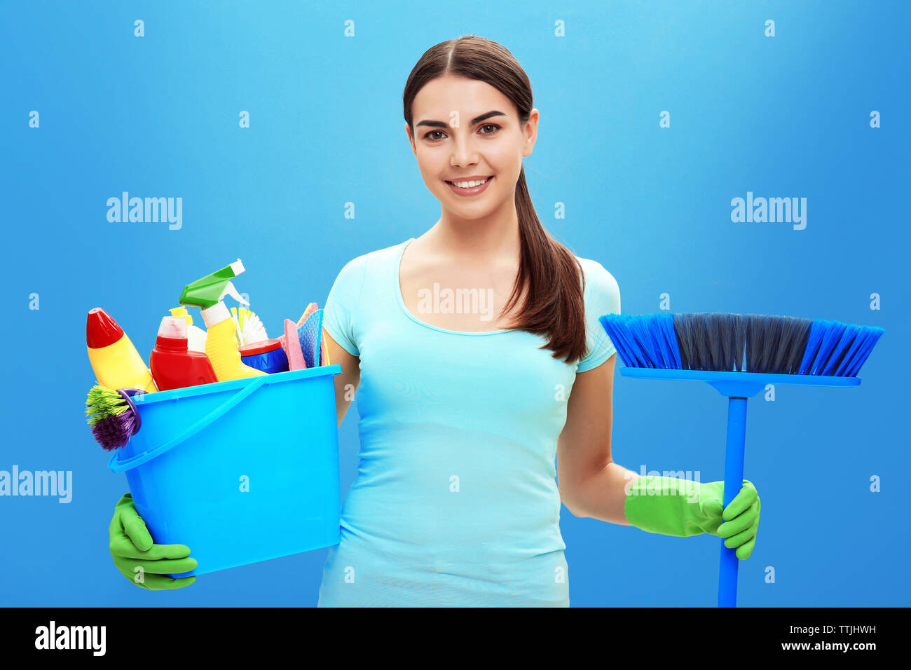 Female cleaner on blue background Stock Photo - Alamy
